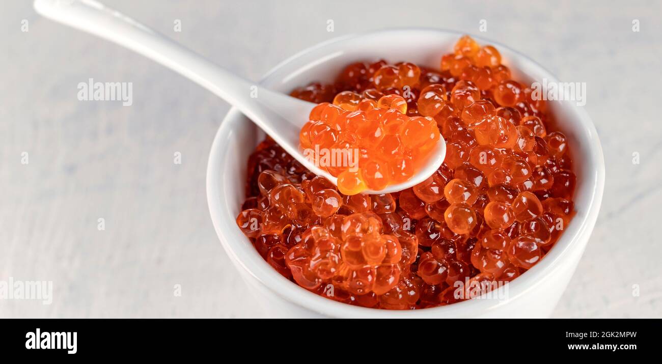 banner with close up delicious, crumbly, large red caviar in a white ...