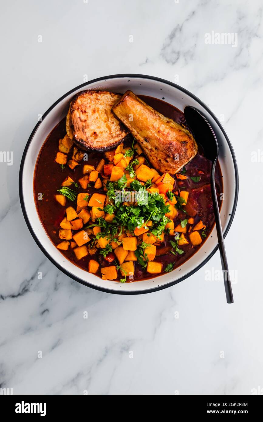 vegan butter chicken curry with pumpkin swede and parsnip topped with ...