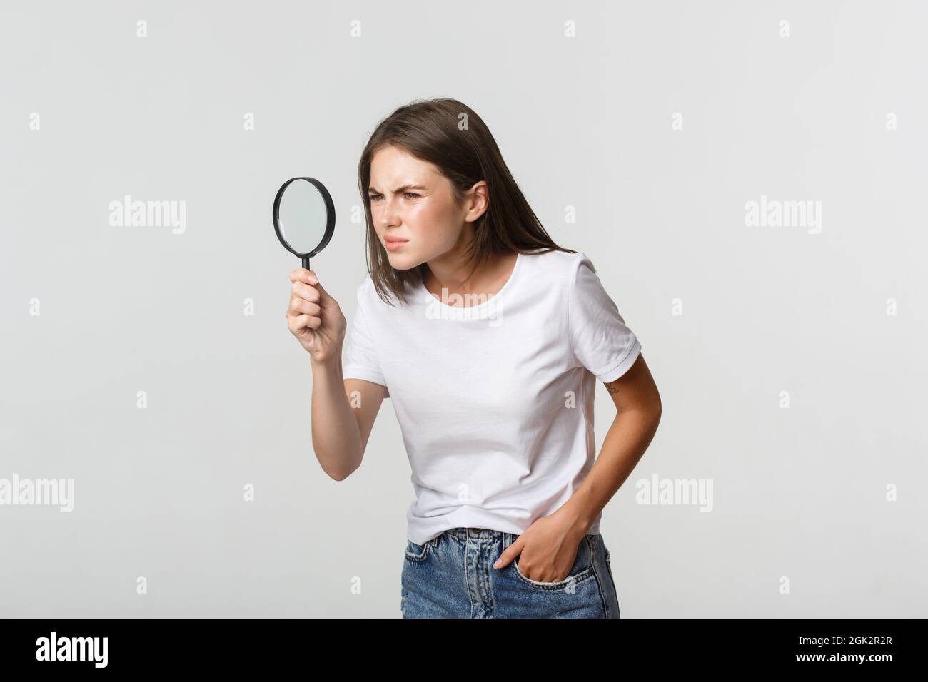 Serious-looking attractive young woman searching for something, looking ...