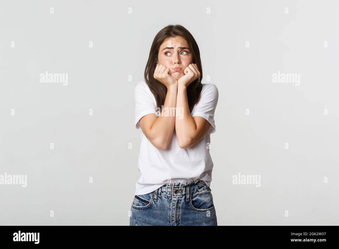 Nervous sad brunette girl leaning on hands and looking left miserable ...