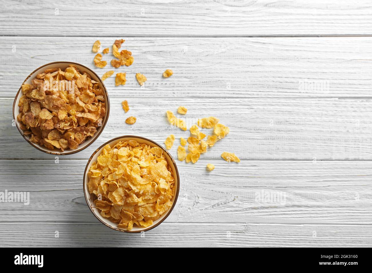 Bowls with different healthy cornflakes on wooden background Stock ...