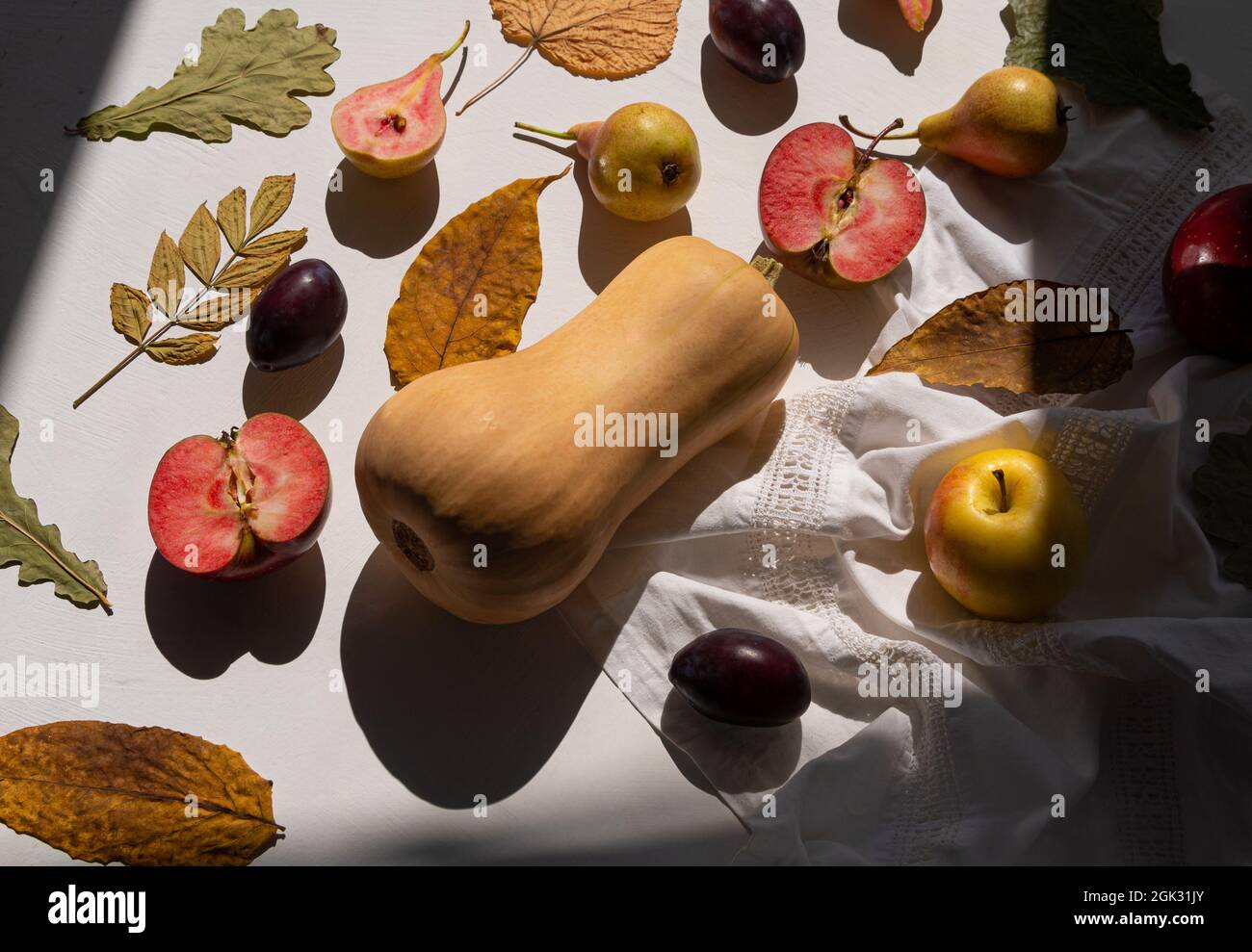 Autumn flat lay with pumpkin apples pears plums and fall leaves with ...