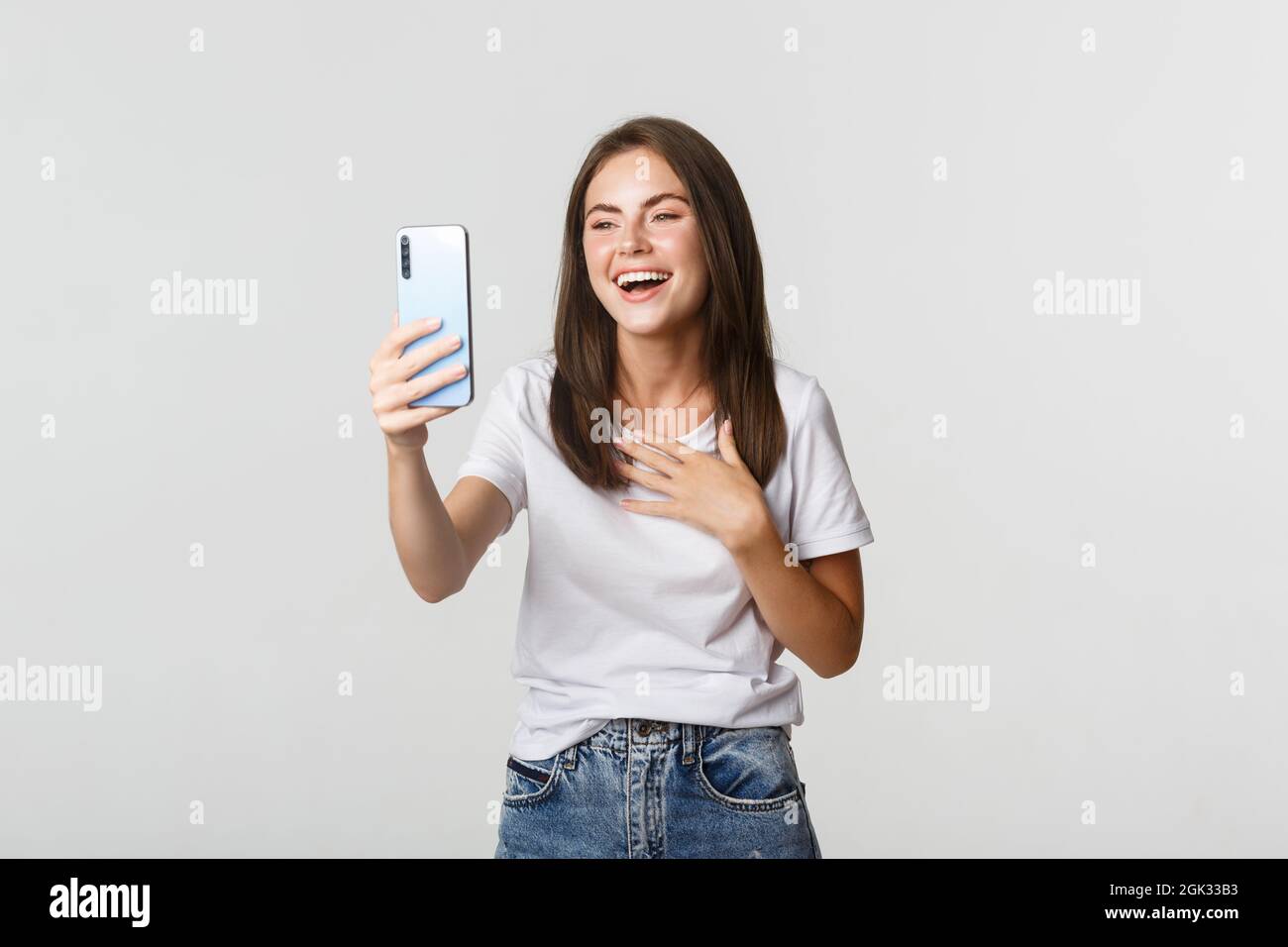 Friendly smiling woman video calling and talking on smartphone happy ...