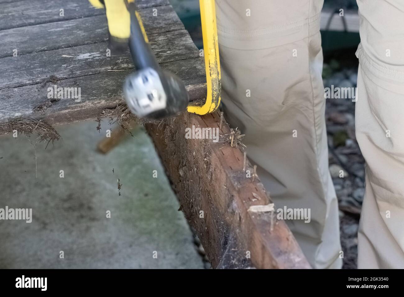 metal mallet hammering in crowbar under porch Stock Photo - Alamy