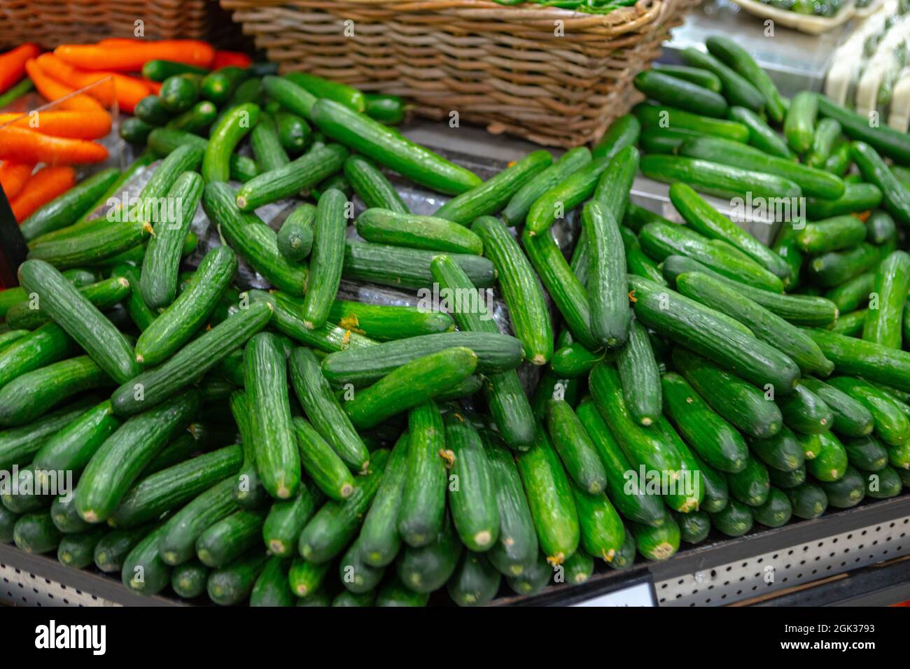 Pile of fresh cucumbers on counter in supermarket Stock Photo - Alamy