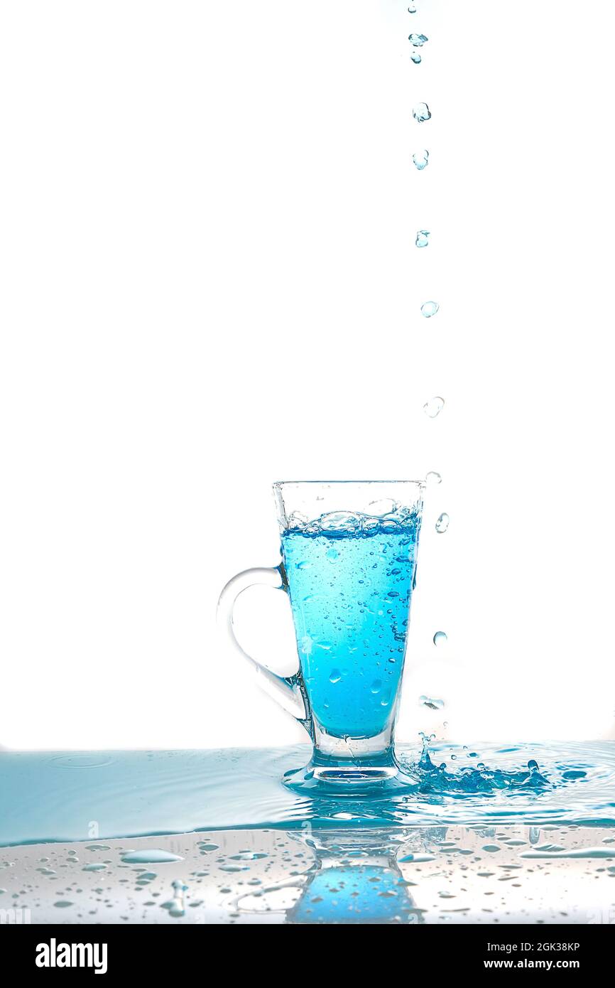 Water splashing into glass of water on white background Stock Photo - Alamy