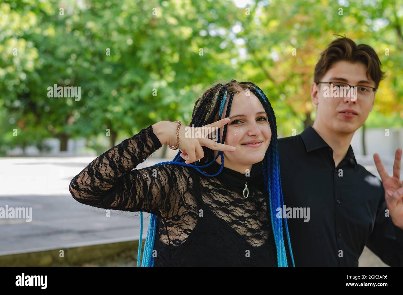A young couple showing victory gestures with their hands against Stock ...