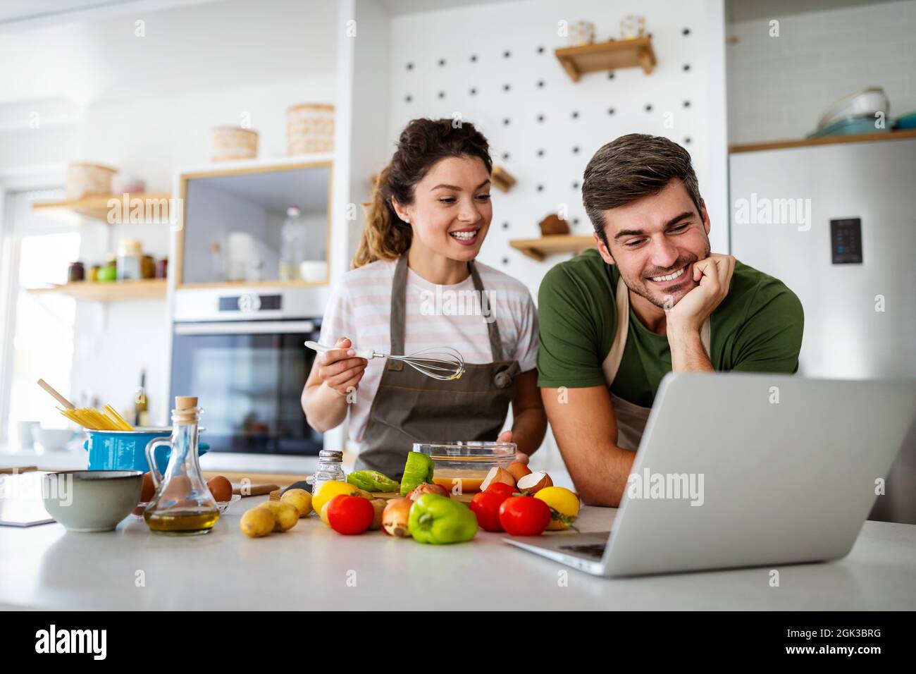 Happy young couple have fun in kitchen while preparing healthy organic ...