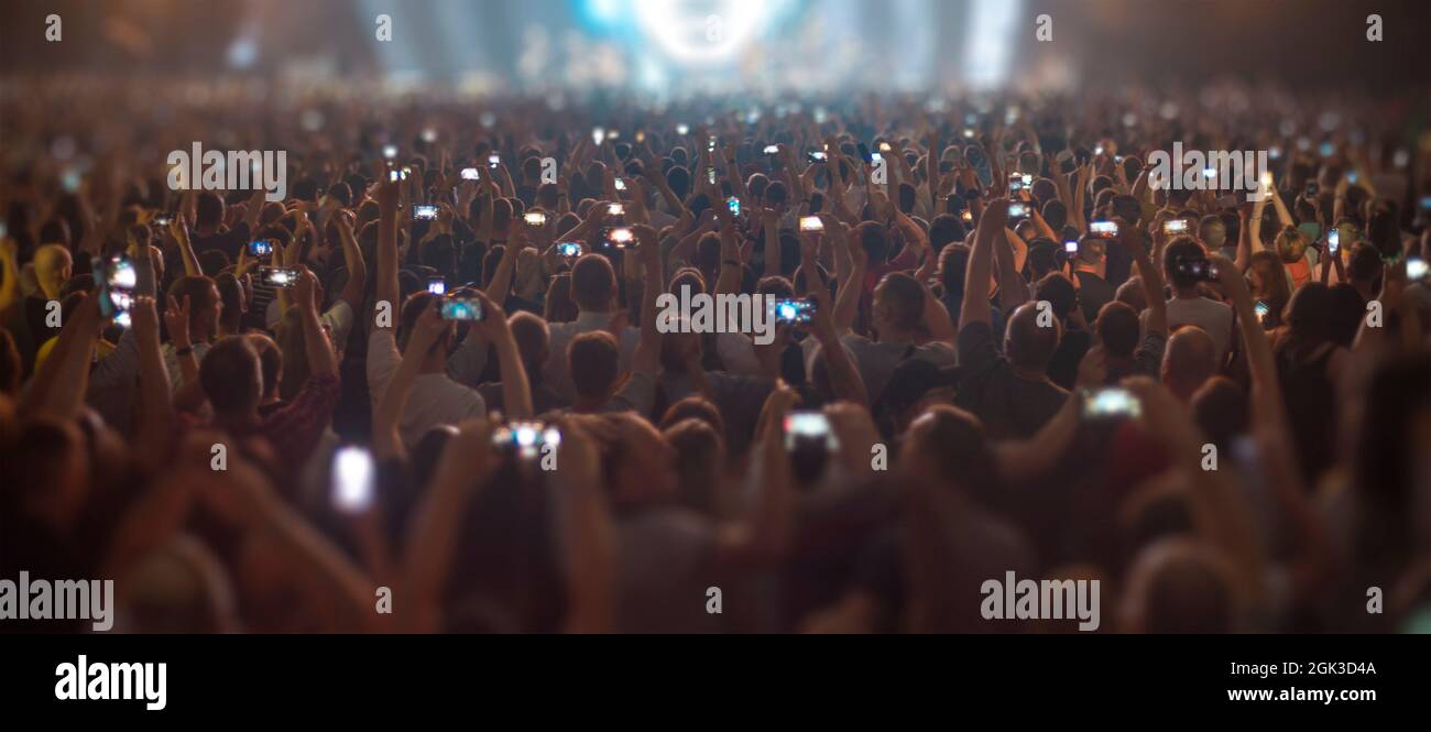 people at a concert are filming an artist's performance on a smartphone ...