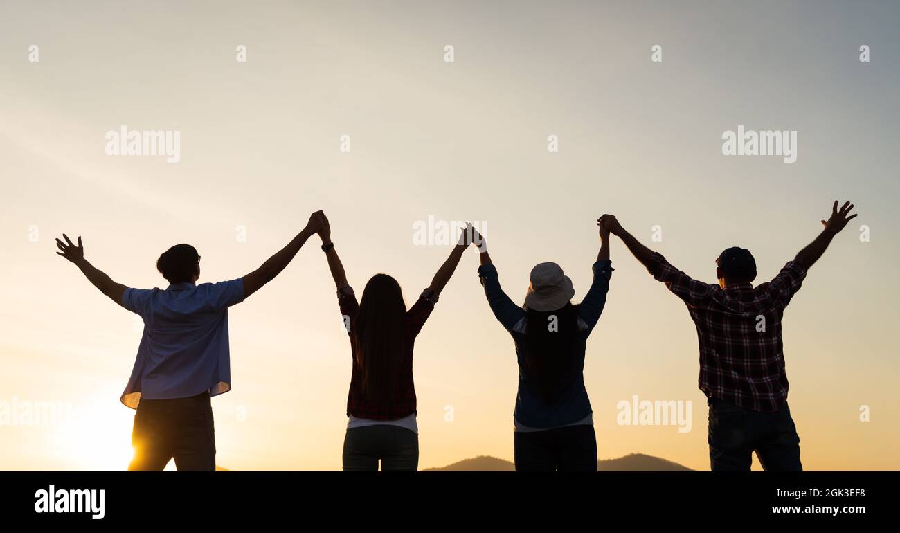 Group of happy friends are having fun with raised arms together in ...