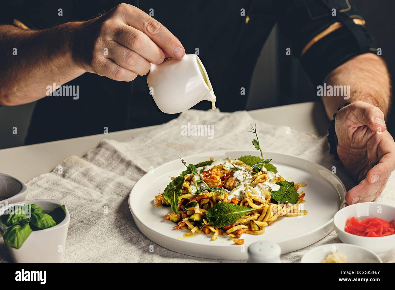 The hands of the head chef prepares a traditional pasta with seafood ...