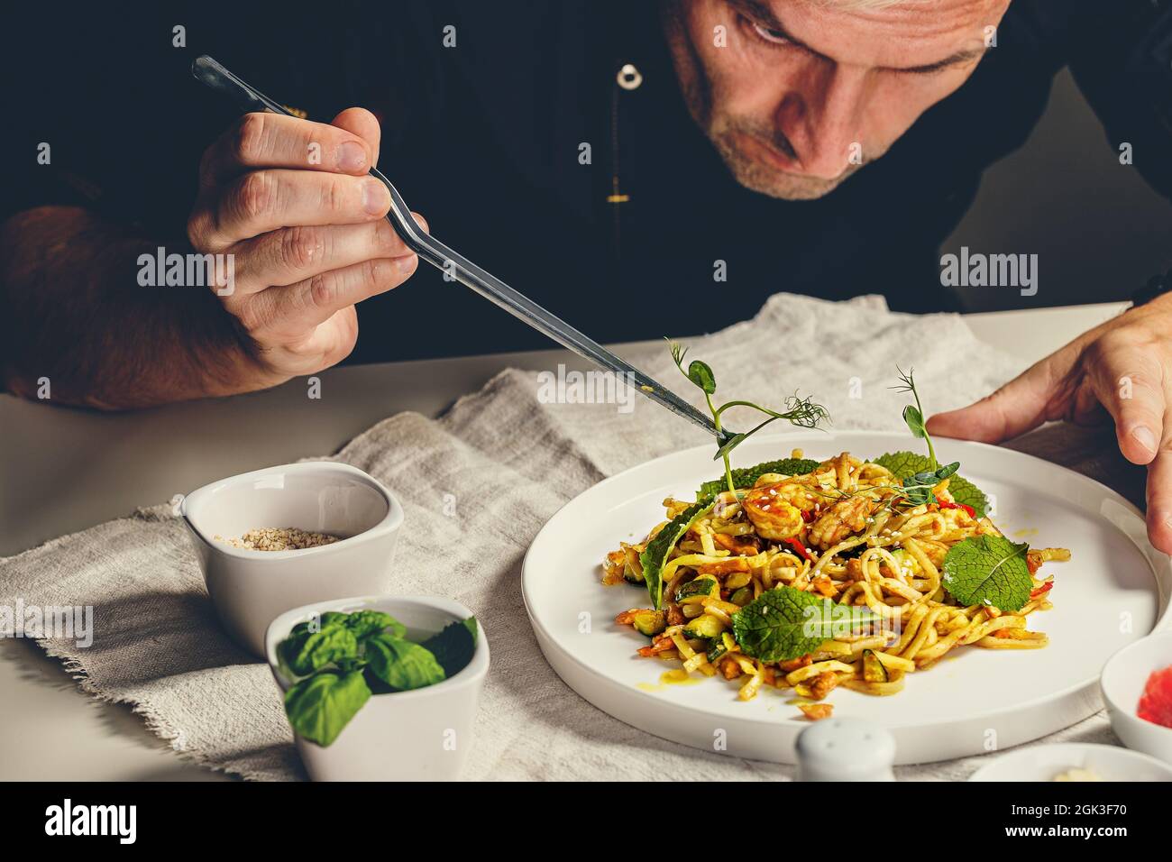 The chef prepares traditional seafood pasta marinara. The chef ...