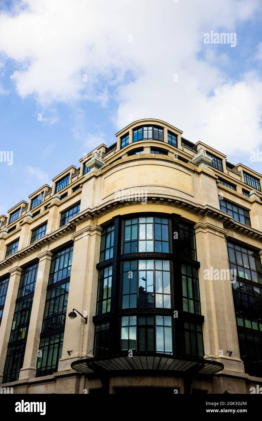 Vertical low angle shot of a building full of blue windows under the cloudy skies Stock Photo ...