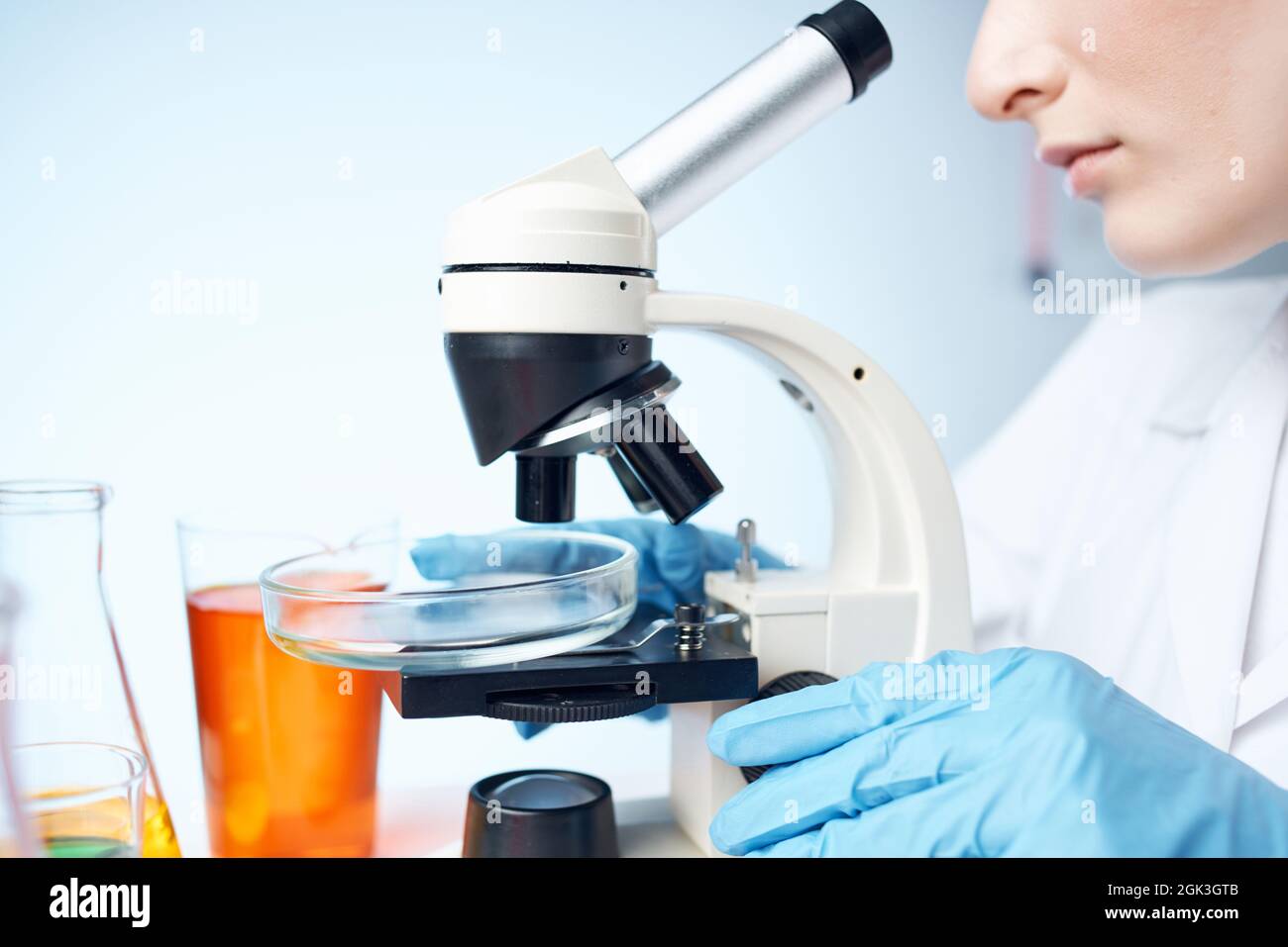female doctor sitting at the table microscope research light background ...