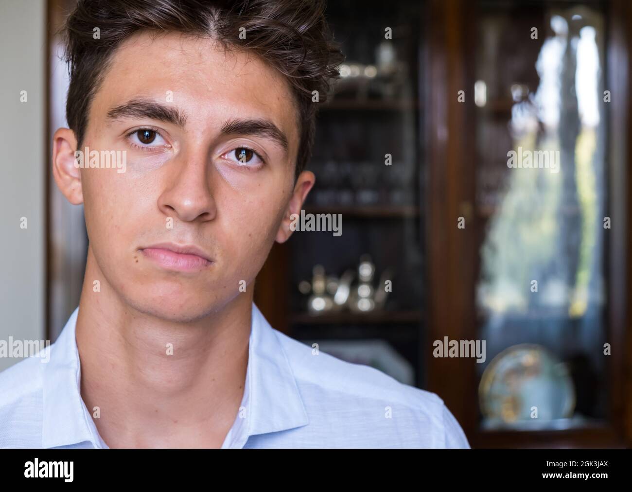 Young man with serious face expression. Close up on student face while ...