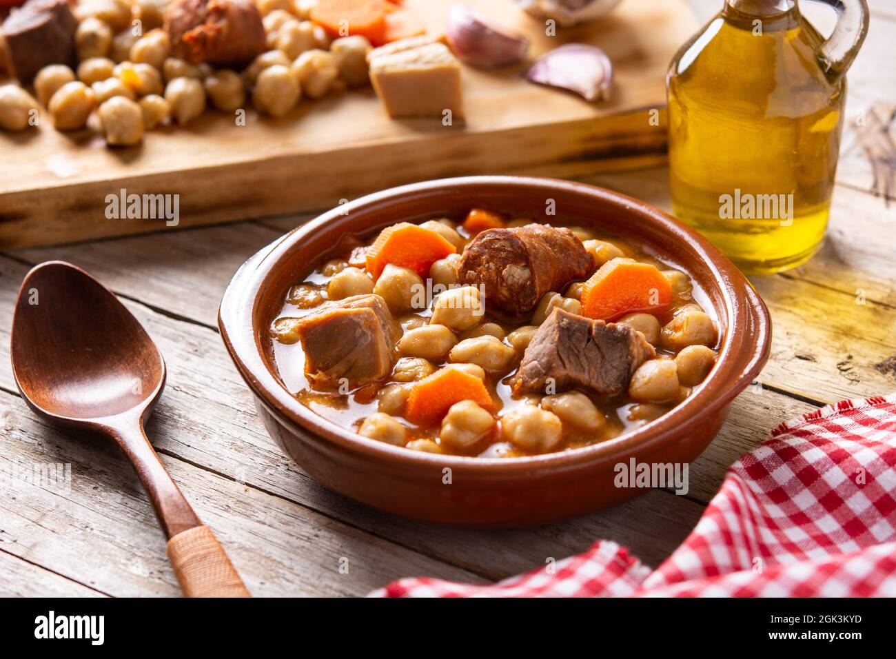 Traditional Spanish cocido madrileño. Chickpea stew on wooden table ...