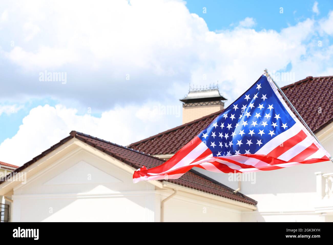 House roof and waving USA flag on blue sky background Stock Photo - Alamy