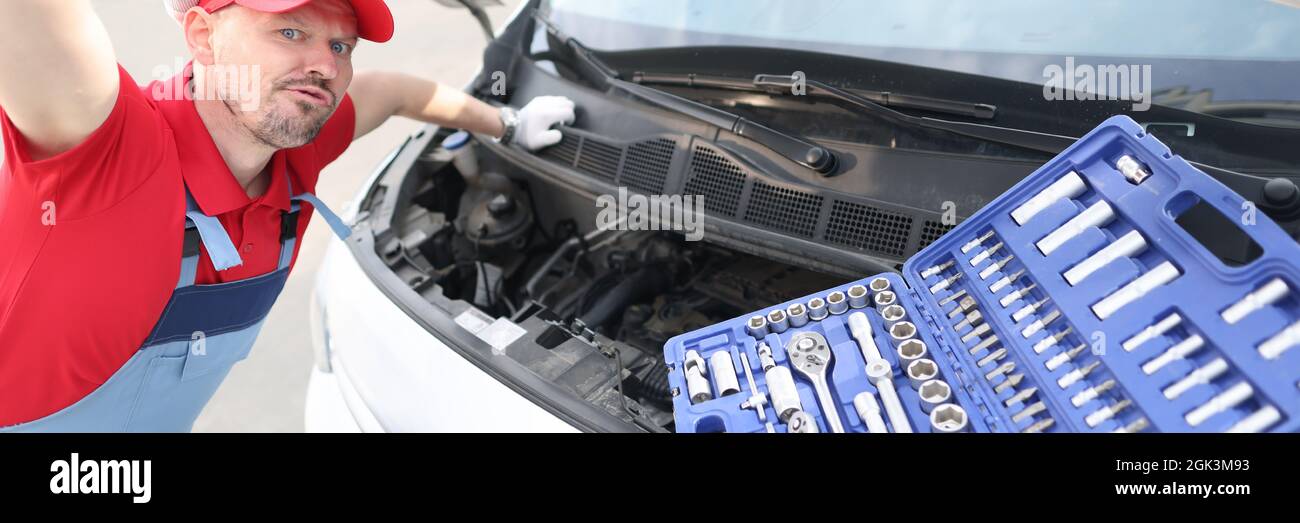 Male auto mechanic stands next to open hood of car Stock Photo - Alamy