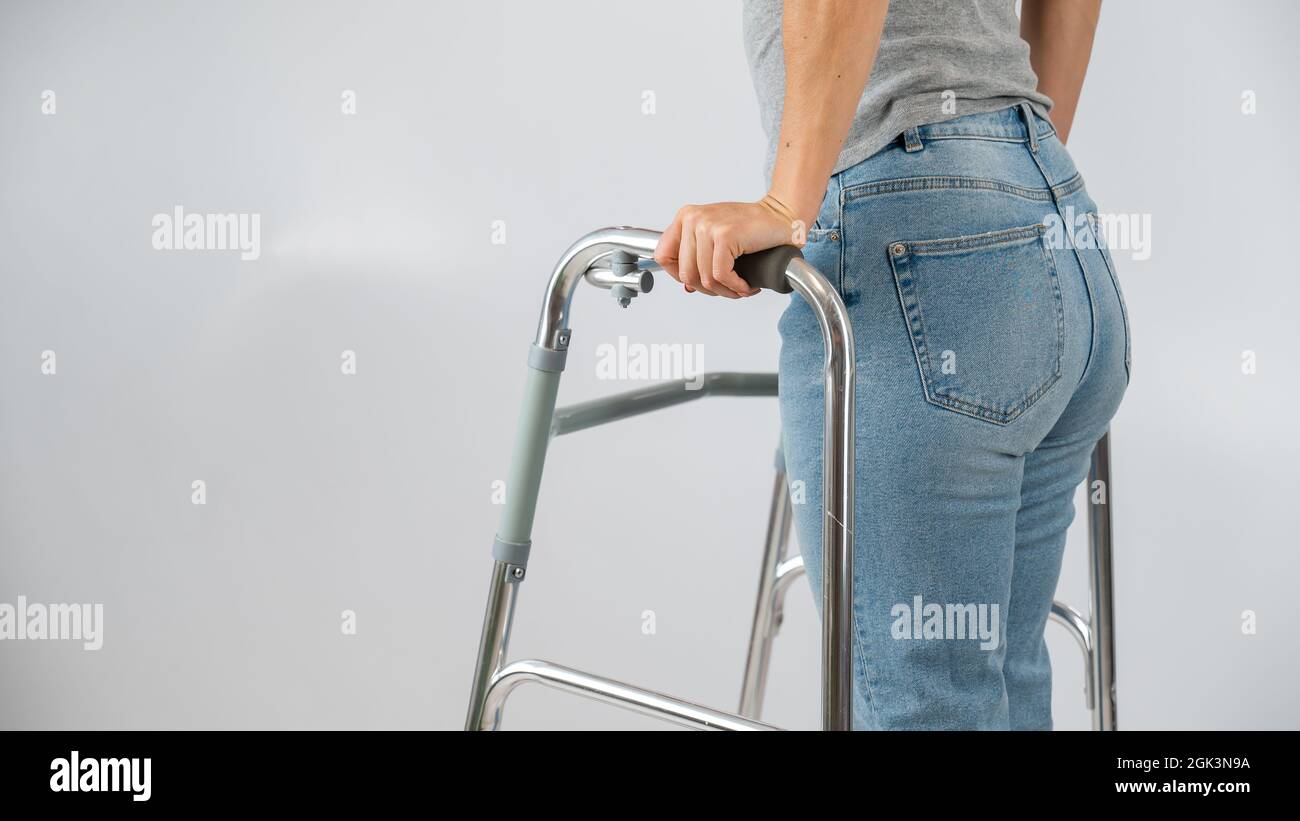 A woman is walking with a walker on a white background Stock Photo - Alamy