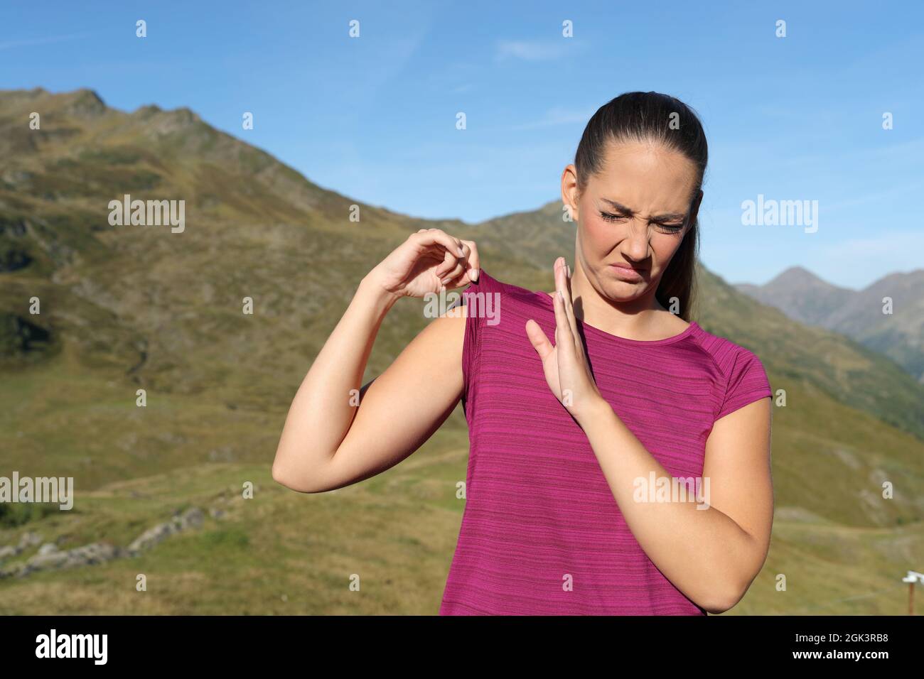 Sportswoman smelling stinky clothes after sport in nature Stock Photo ...