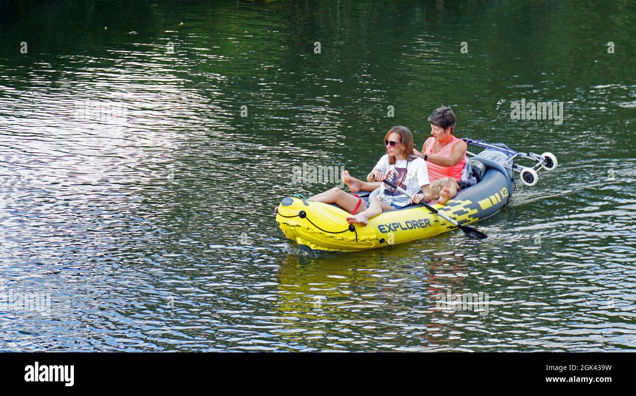 Two women in inflatable kayak paddling on river Stock Photo - Alamy