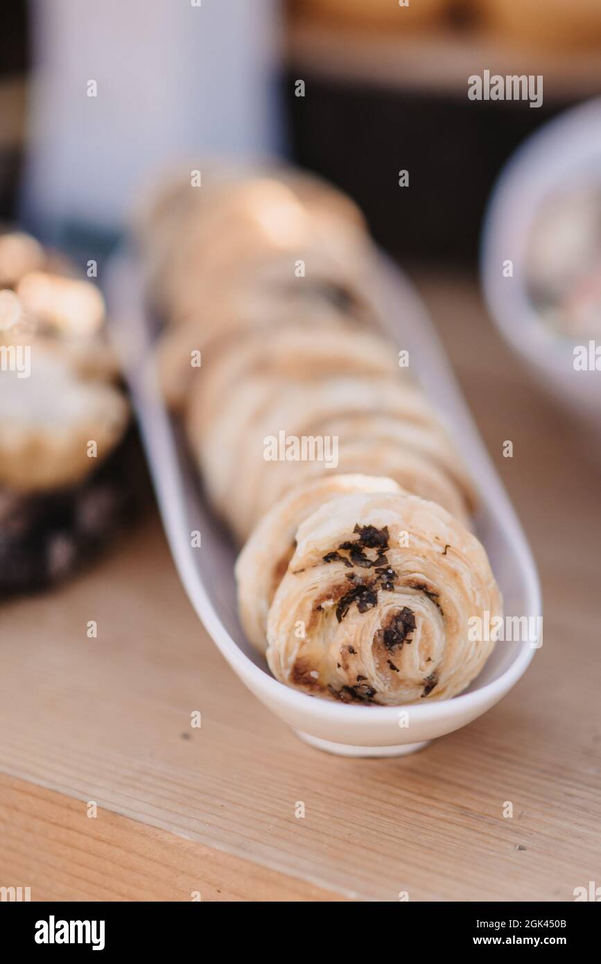 Vertical closeup of a narrow plate with roll cakes. Selected focus ...
