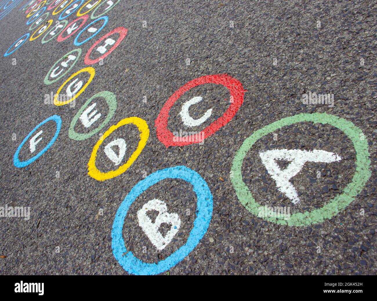 Letters of the alphabet in colored circles on an asphalt road Stock ...