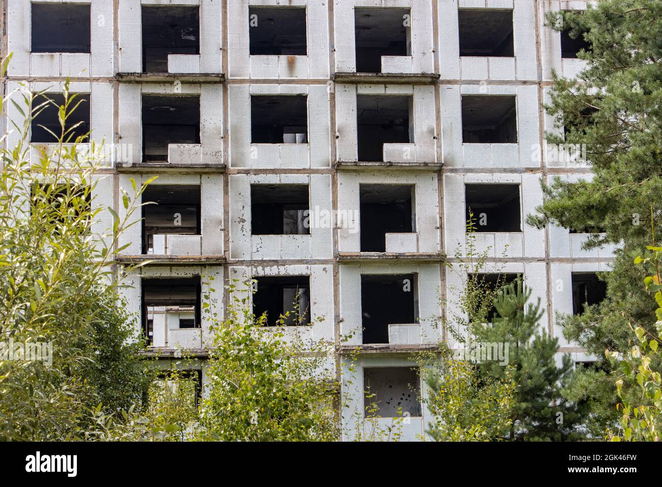 A damaged abandoned panel house with decorative facade of small white ...