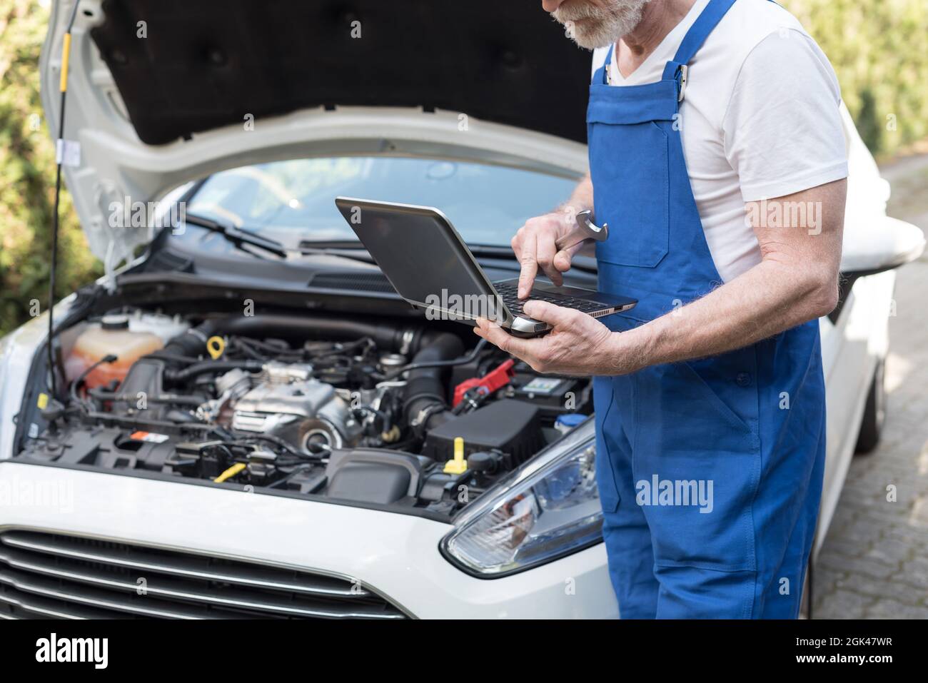 Car mechanic using laptop for checking car engine Stock Photo - Alamy
