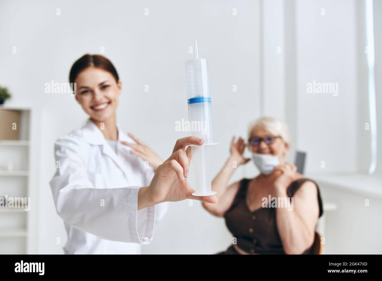emotional nurse and patient injection into hospital arm Stock Photo - Alamy
