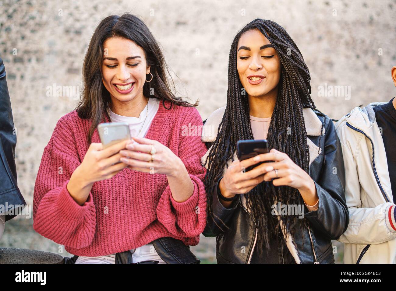 Two women best friends using smartphone together standing outdoors. Gen ...