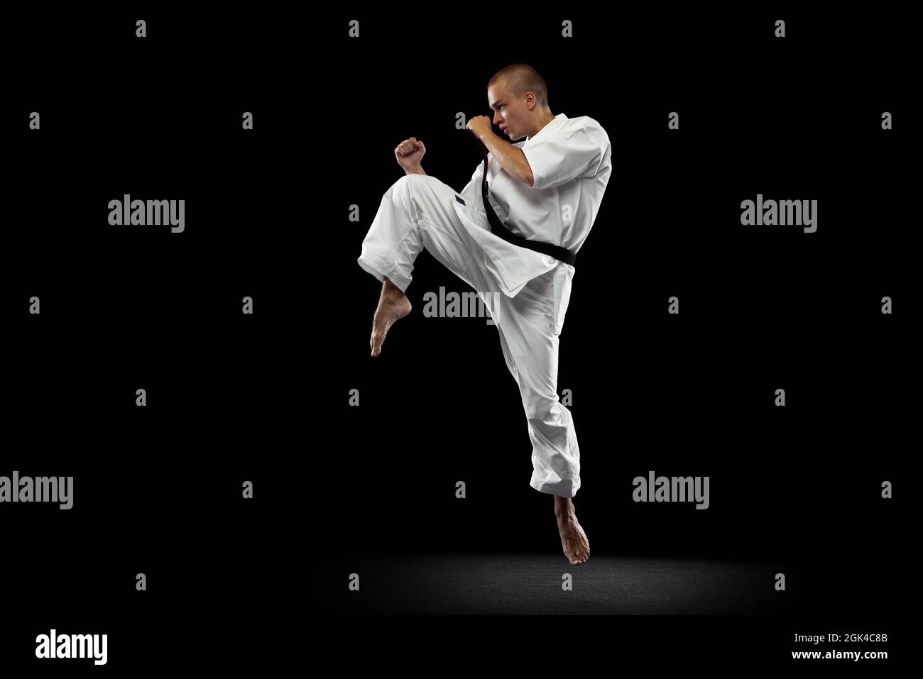 Full-length portrait of young sportsman training karate isolated over ...