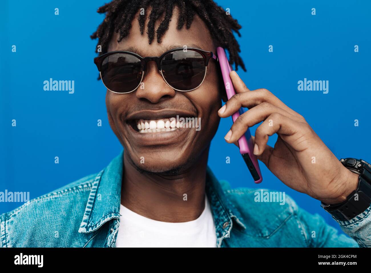 african man calling on the phone on a blue background, 5g internet ...