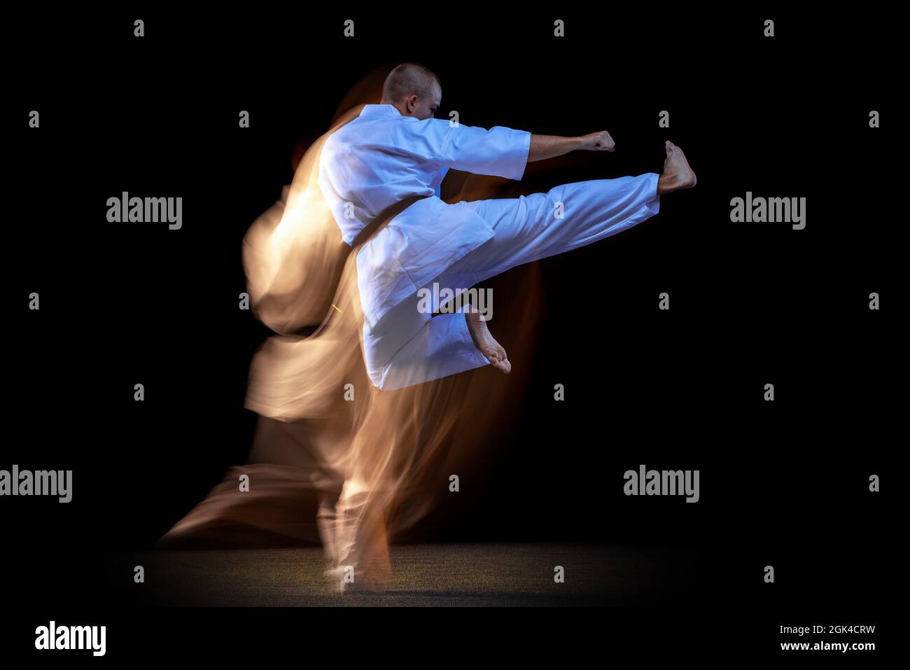 Back view portrait of karate sportsman practising isolated over black ...