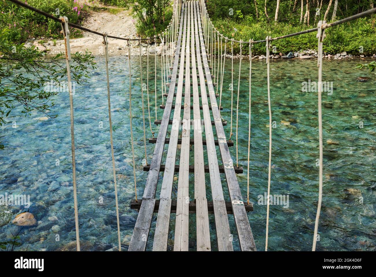 Rickety footbridge over rushing river Stock Photo - Alamy