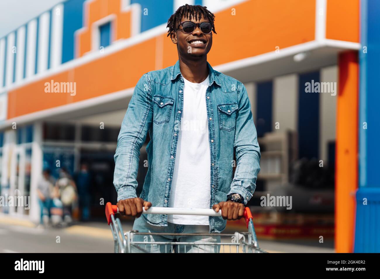 afro american black man with shopping cart in front of mall shopping ...