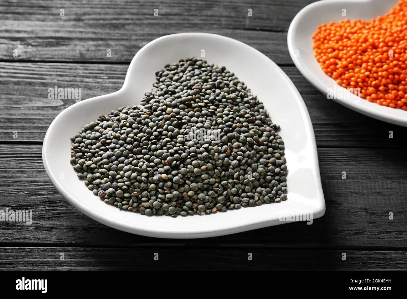 Plates with black and red lentils on wooden background Stock Photo - Alamy