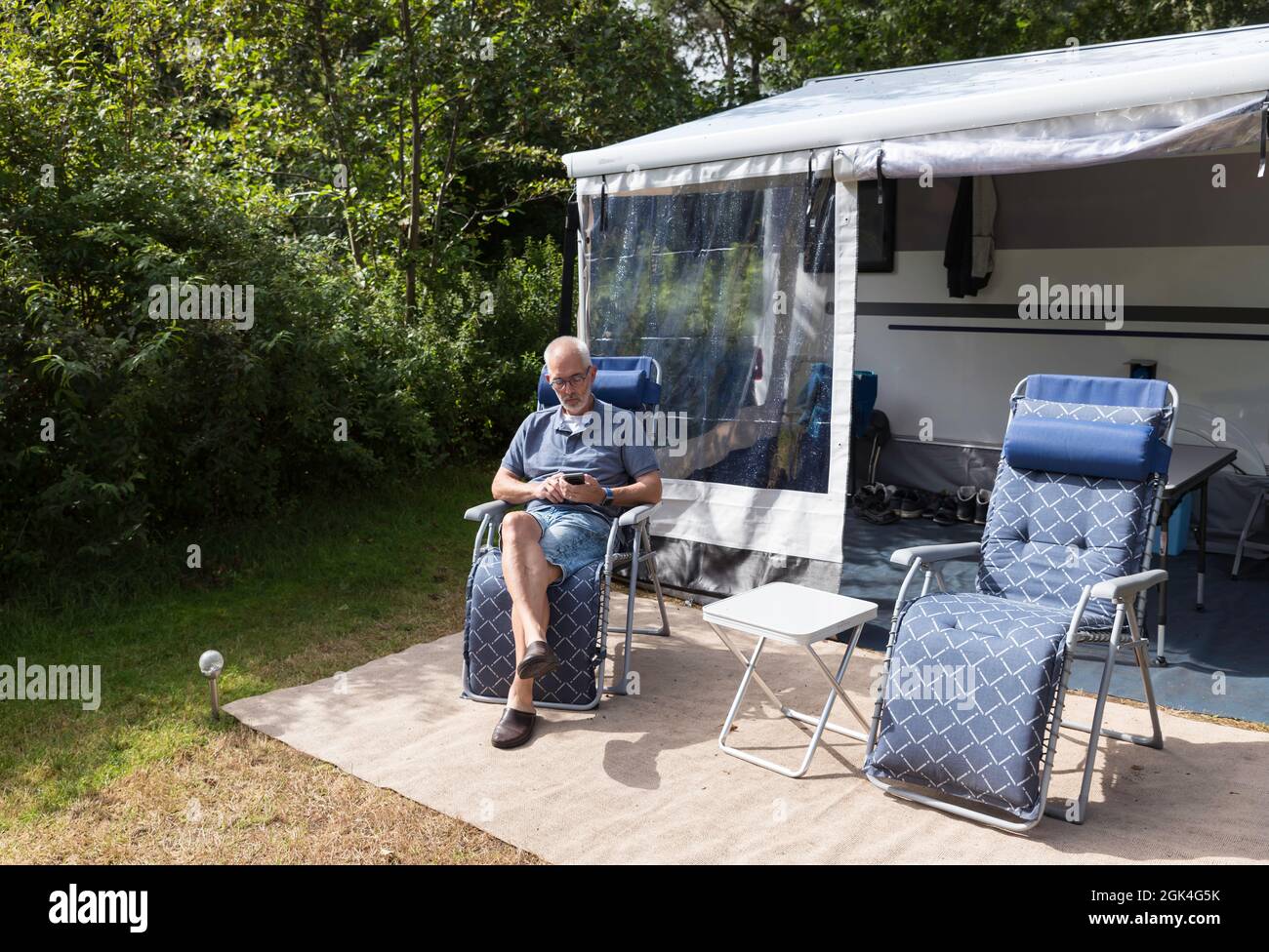 man sitting in front of caravan Stock Photo - Alamy