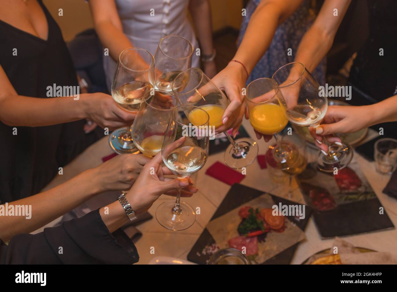 Clinking glasses with alcohol and toasting, party Stock Photo - Alamy
