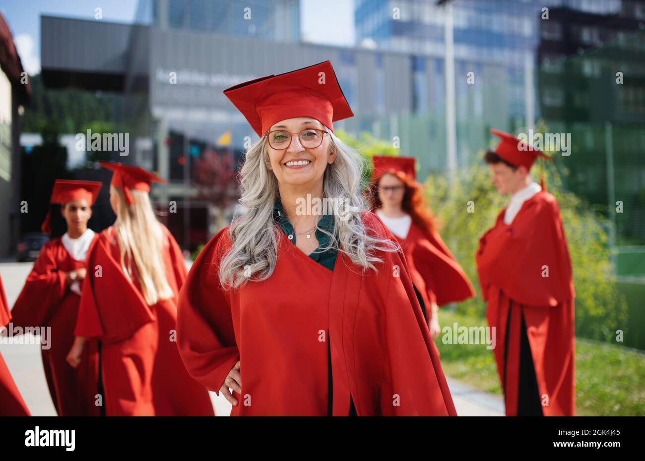 Portrait of cheerful senior woman student outdoors, graduation and ...