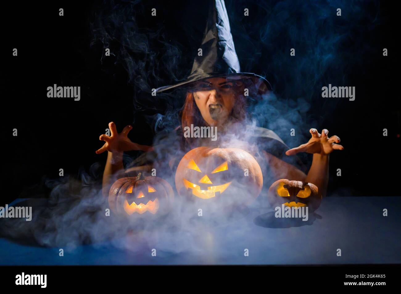 The evil witch casts a spell on pumpkins. Portrait of a woman in a ...
