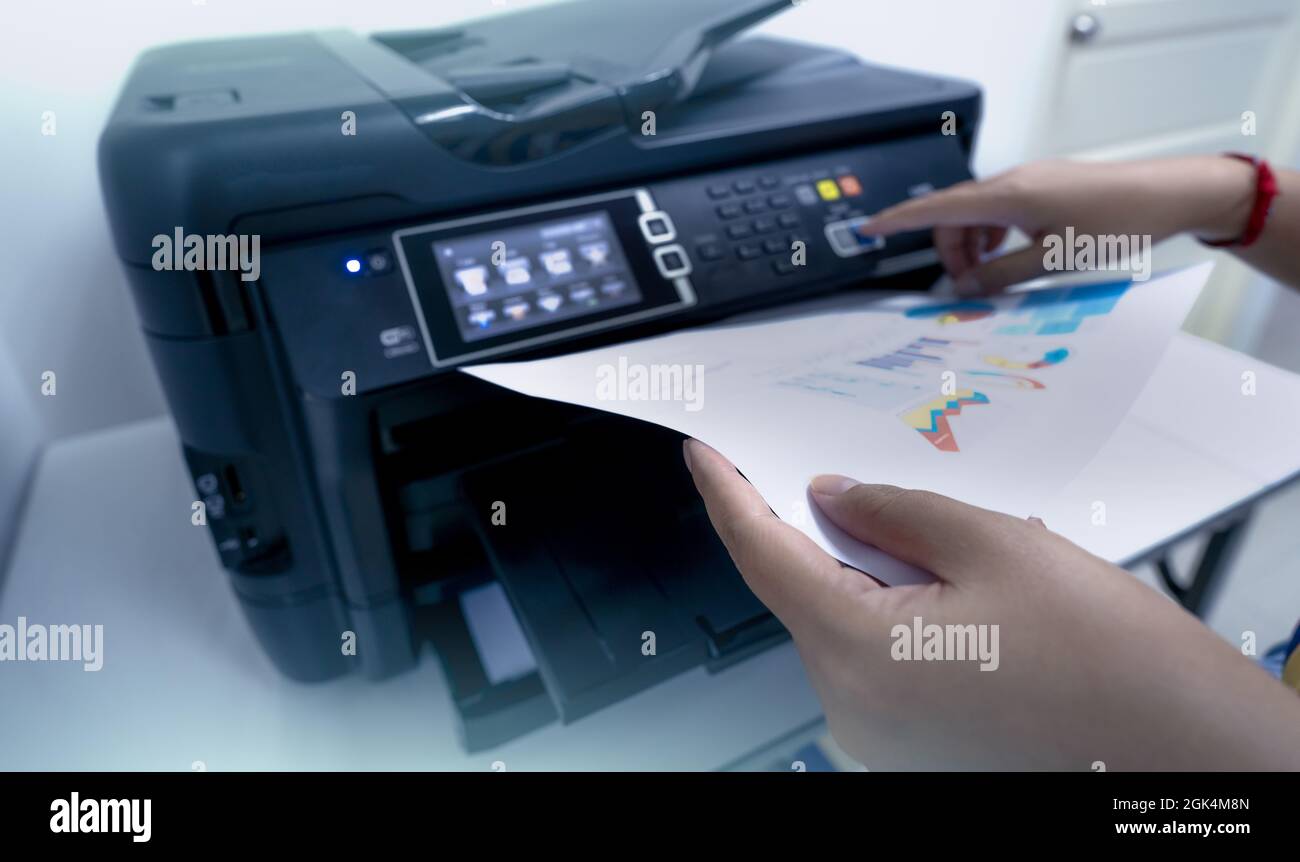 Office worker prints paper on multifunction laser printer. Copy, print ...