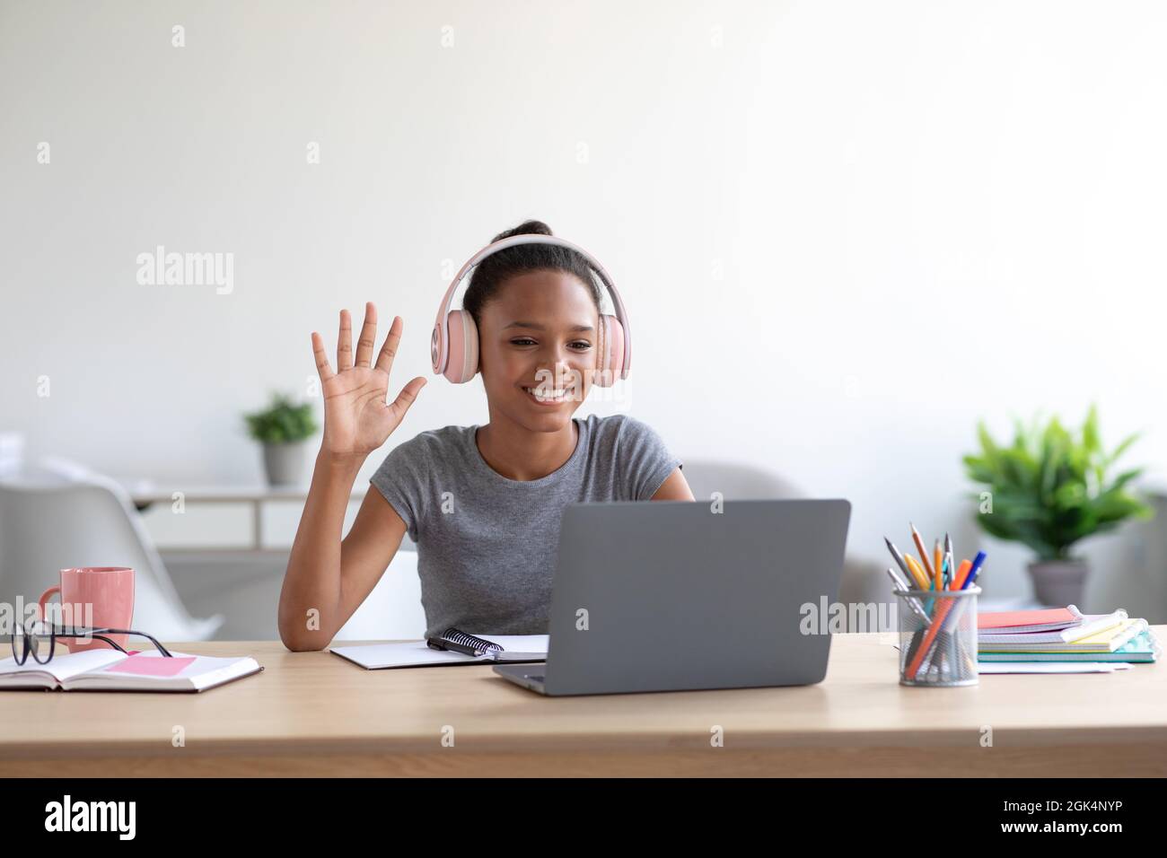 Smiling young afro american female student in headset study at home ...