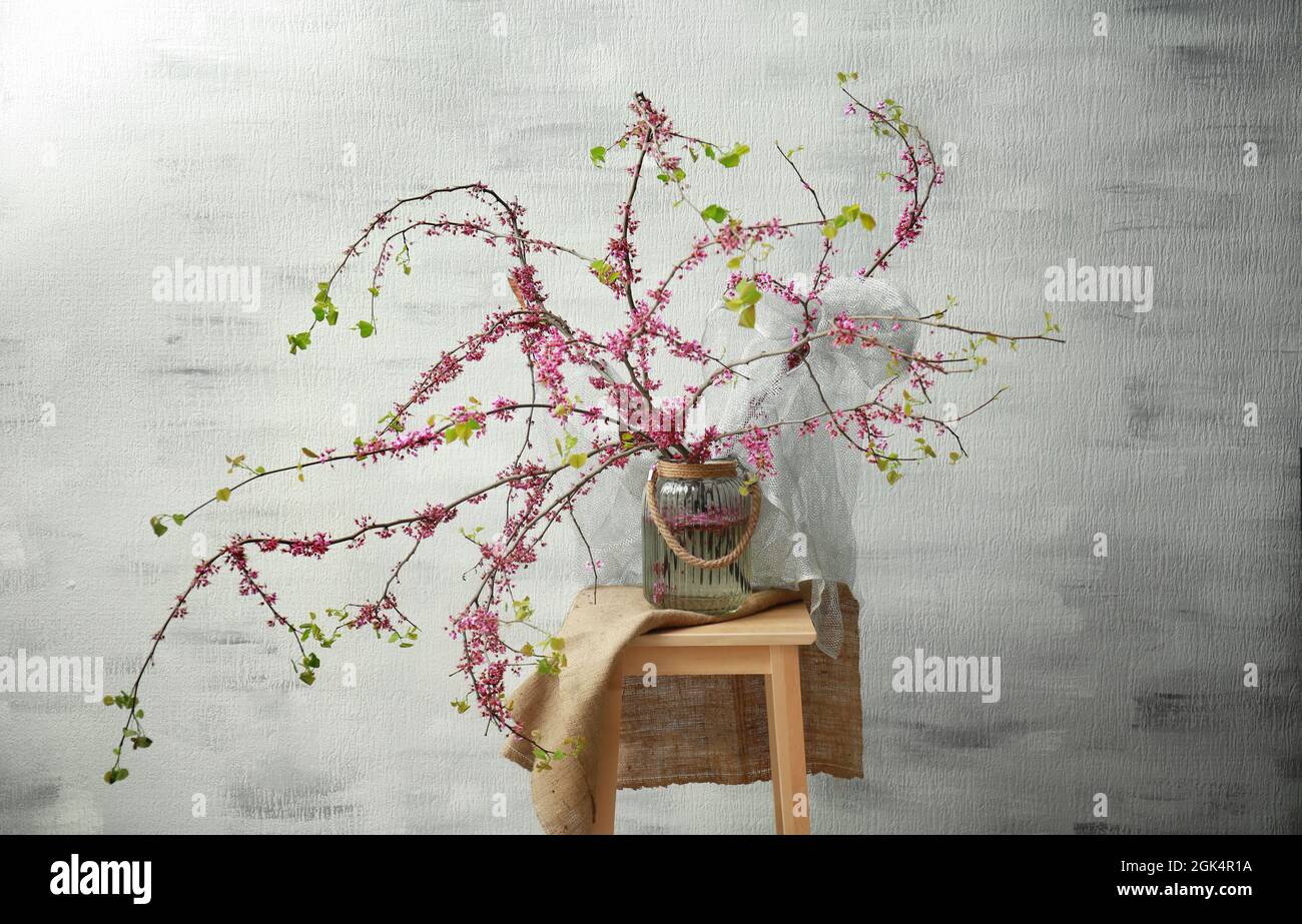 Glass vase with branches of blooming tree flowers on table Stock Photo ...