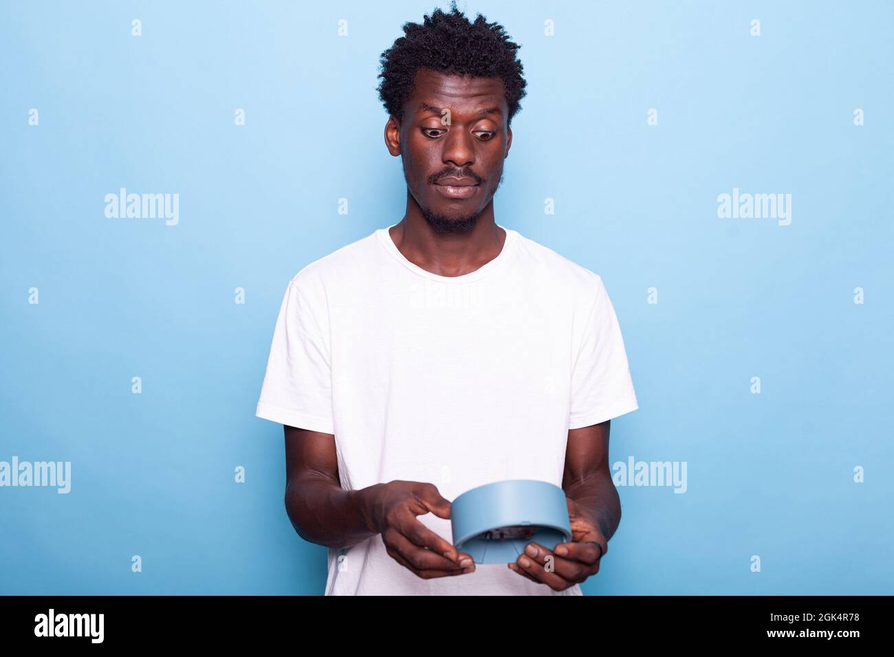 Young adult holding watch in hand and looking at time. Punctual person ... Young adult holding watch in hand and looking at time. Punctual person ...
