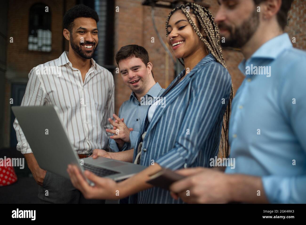 Cheerful young businesspeople with laptop working in office, social ...