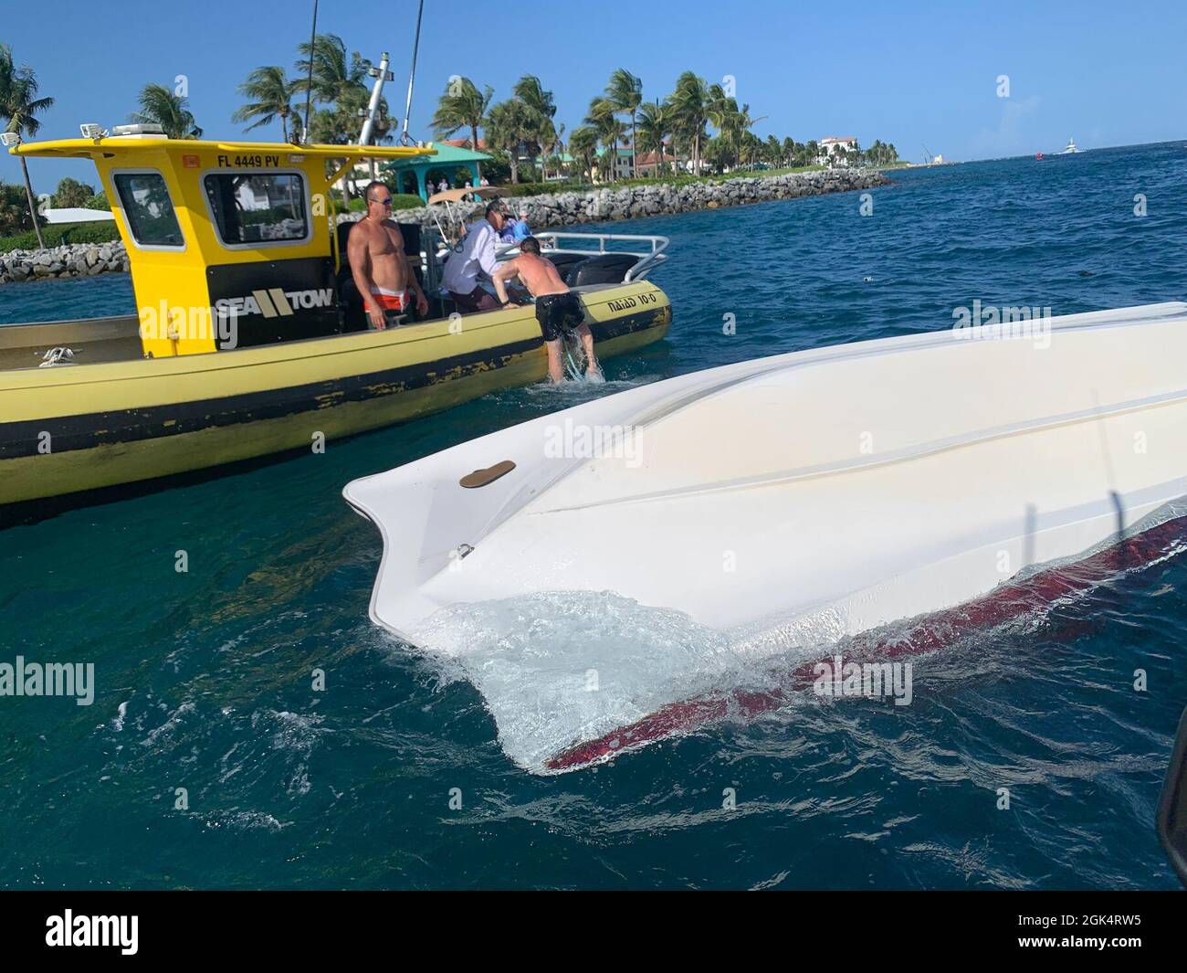 A commercial salvage boat crew rescues a boater from the water after a ...
