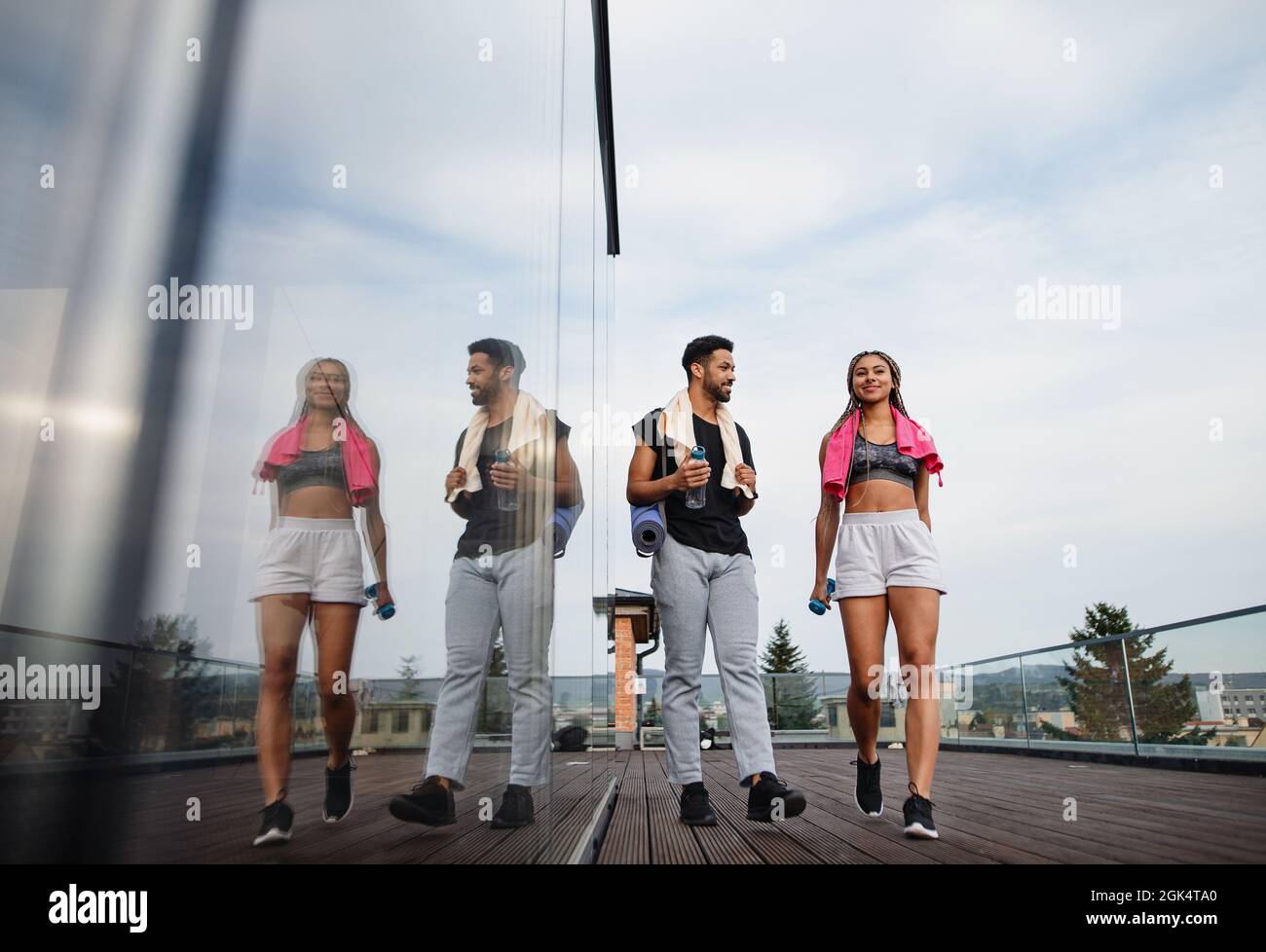 Young couple talking after exercise outdoors on terrace, sport and ...