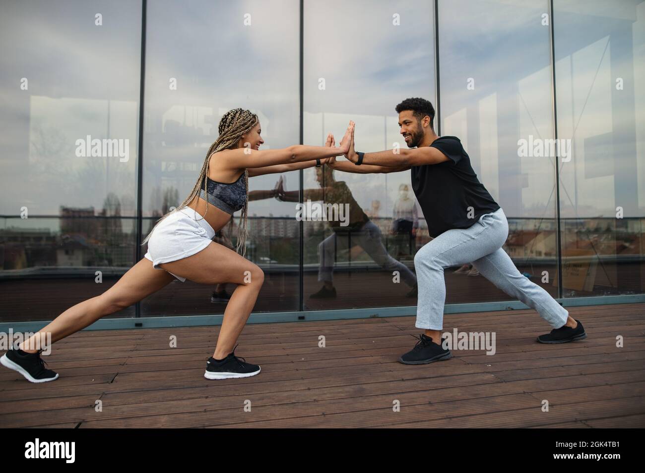 Young couple doing exercise workout outdoors on terrace, sport and ...