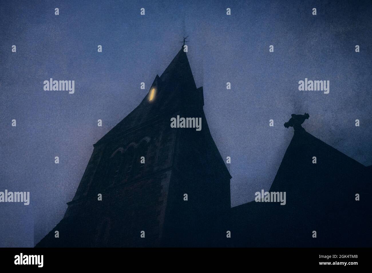 A mysterious glowing light in a window of an old church. On a dark ...